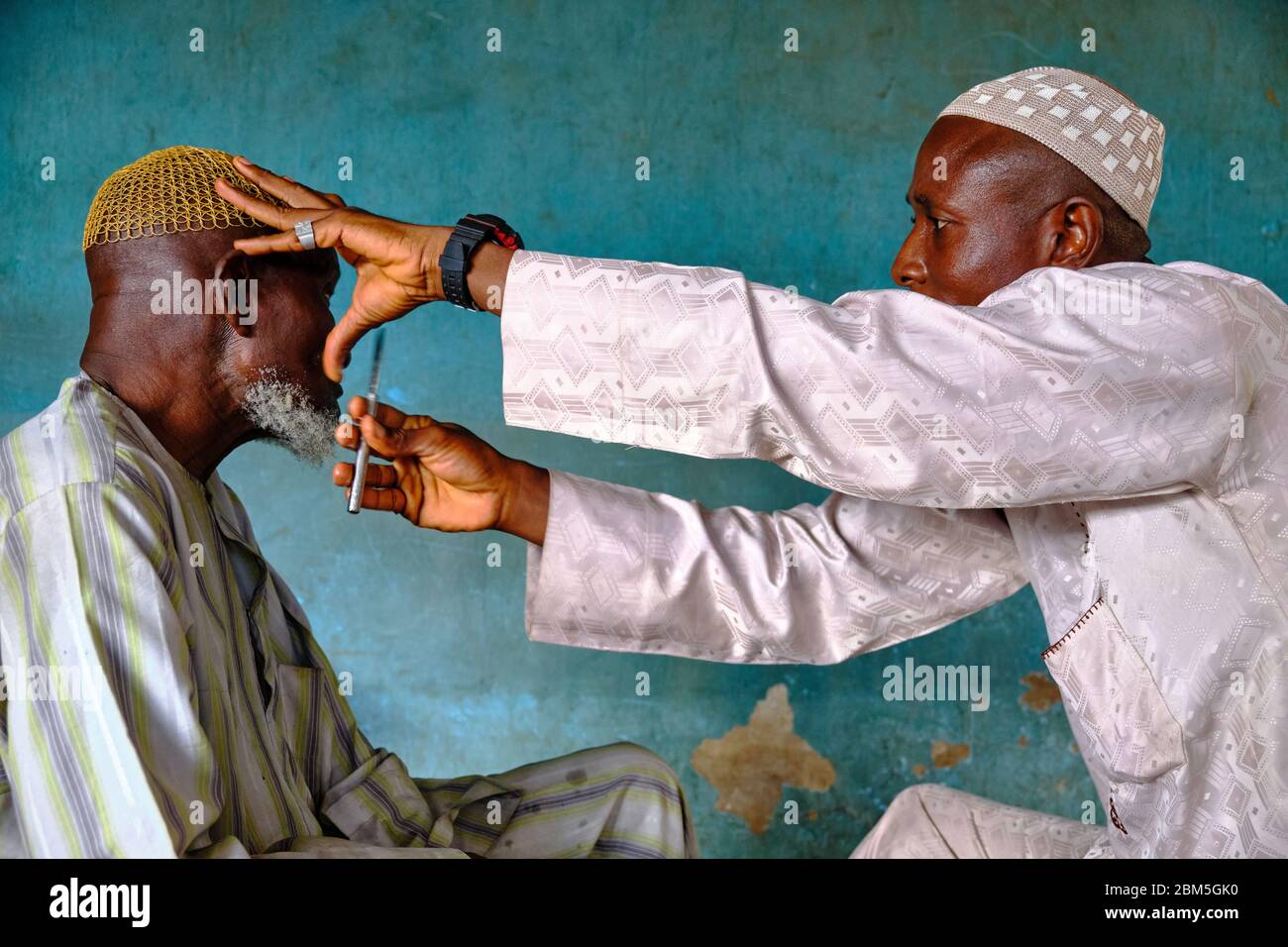 Muslim man shaving the Imam of his mosque with a razor blade Stock ...