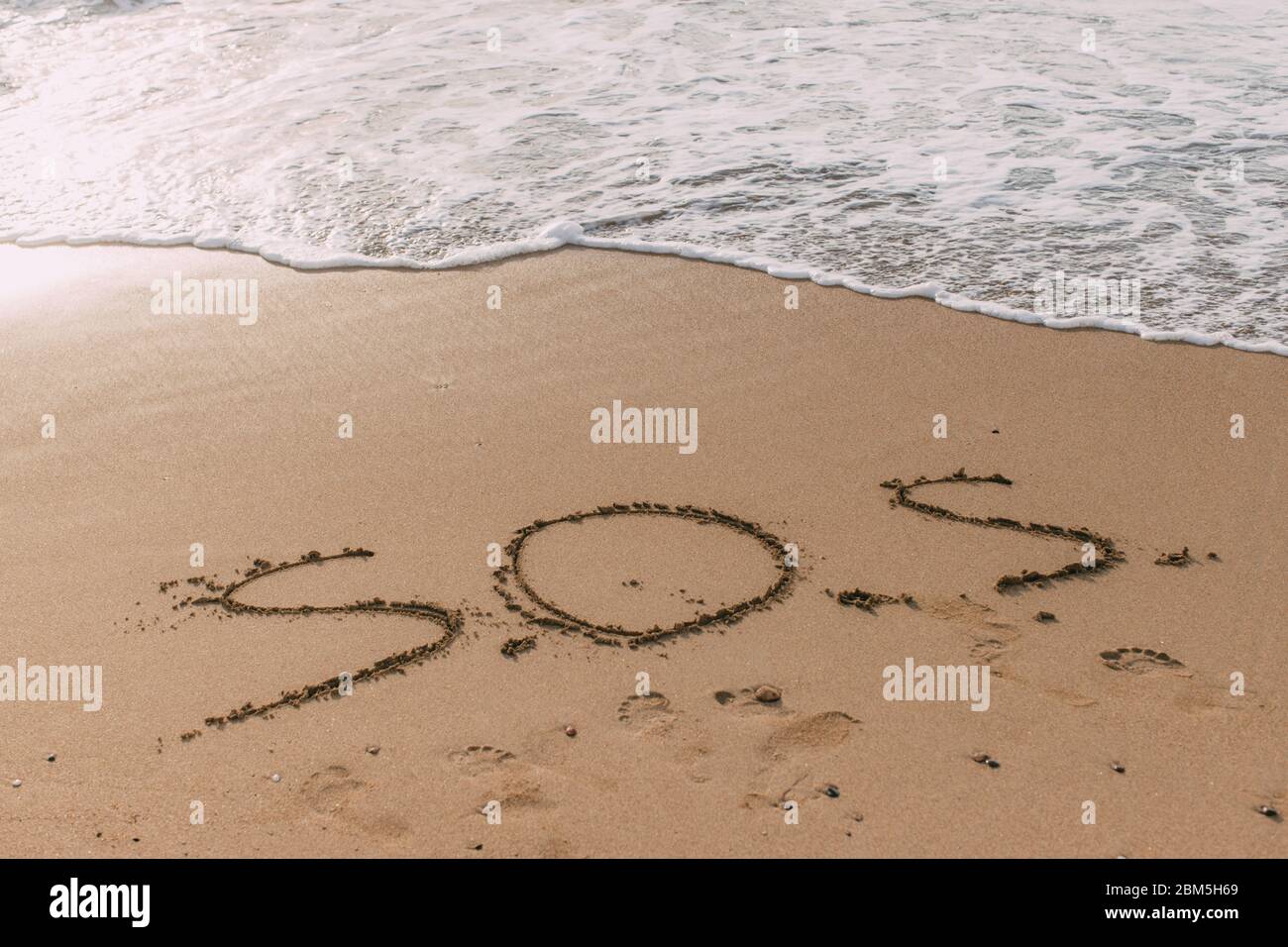 summer beach with sos lettering on sand near sea Stock Photo - Alamy
