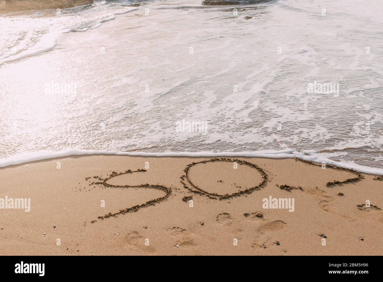 beach with sos lettering on sand near sea Stock Photo - Alamy