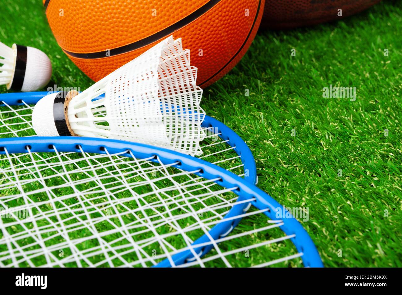 Badminton game rackets and shuttlecock on grass Stock Photo - Alamy