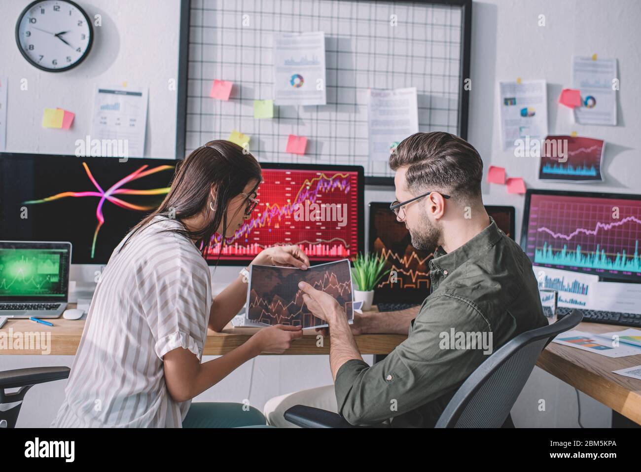 Side view of information security analysts using charts while testing ...