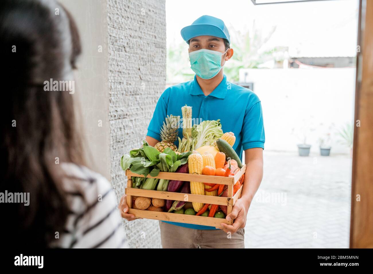 Food delivery during corona virus pandemic. Courier wearing face masks ...