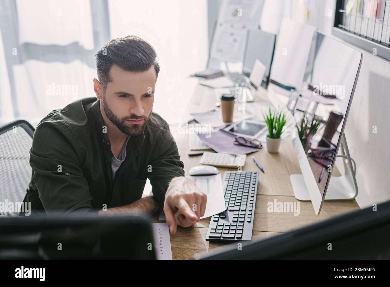 Selective focus of data analyst pointing on computer monitor while working in office Stock Photo ...