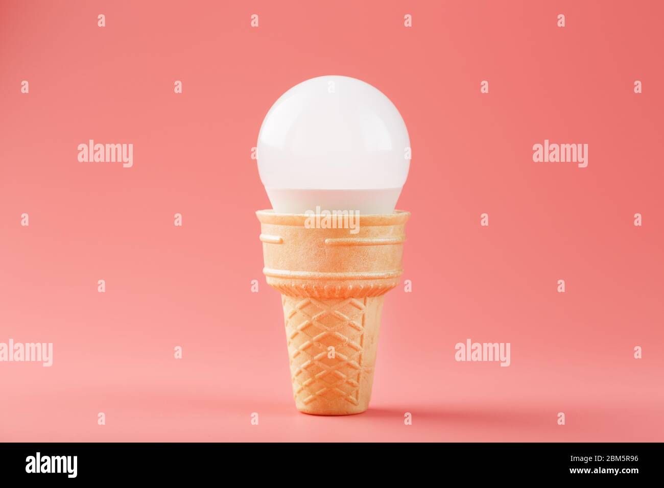 Light bulb ice cream in a waffle Cup on a pink background. Minimalistic ...