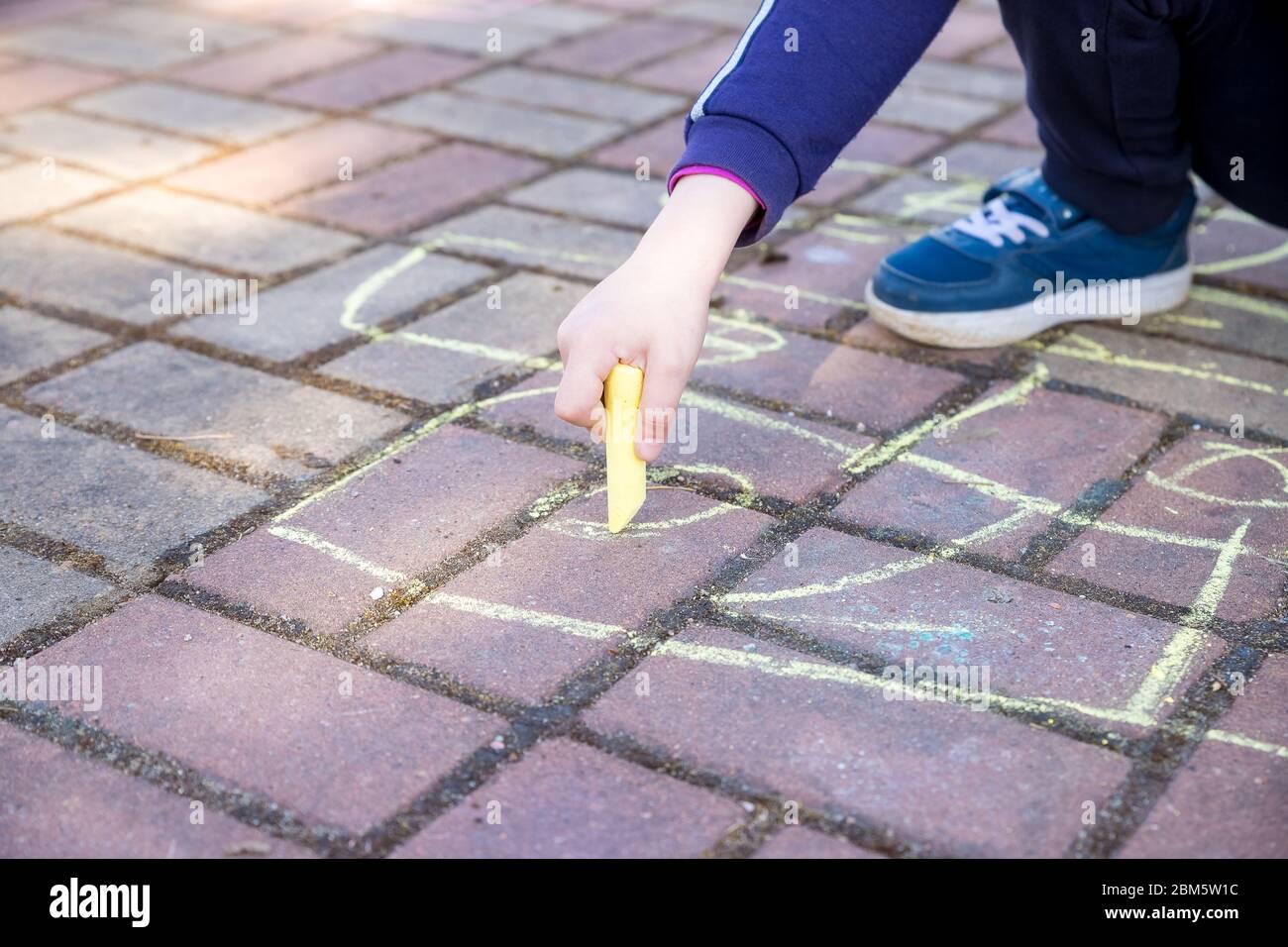 girl sits on concrete asphalt road., on stone pathway. kids painting ...