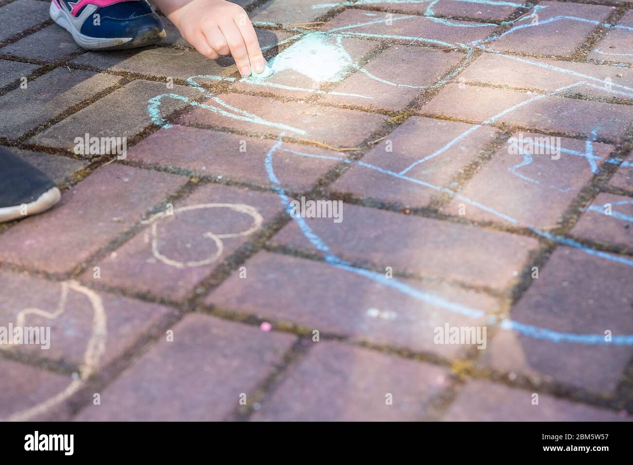 girl sits on concrete asphalt road., on stone pathway. kids painting ...