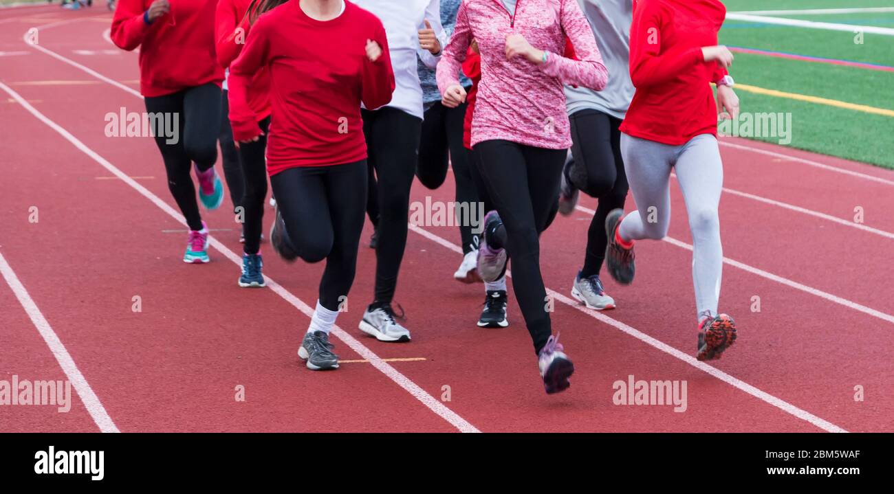 A high school cross country and track teams run together in a group on ...