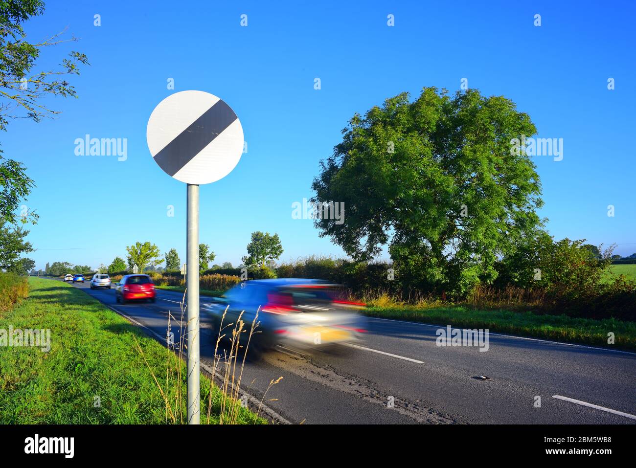 cars passing derestricted roadside speed limit warning sign united ...