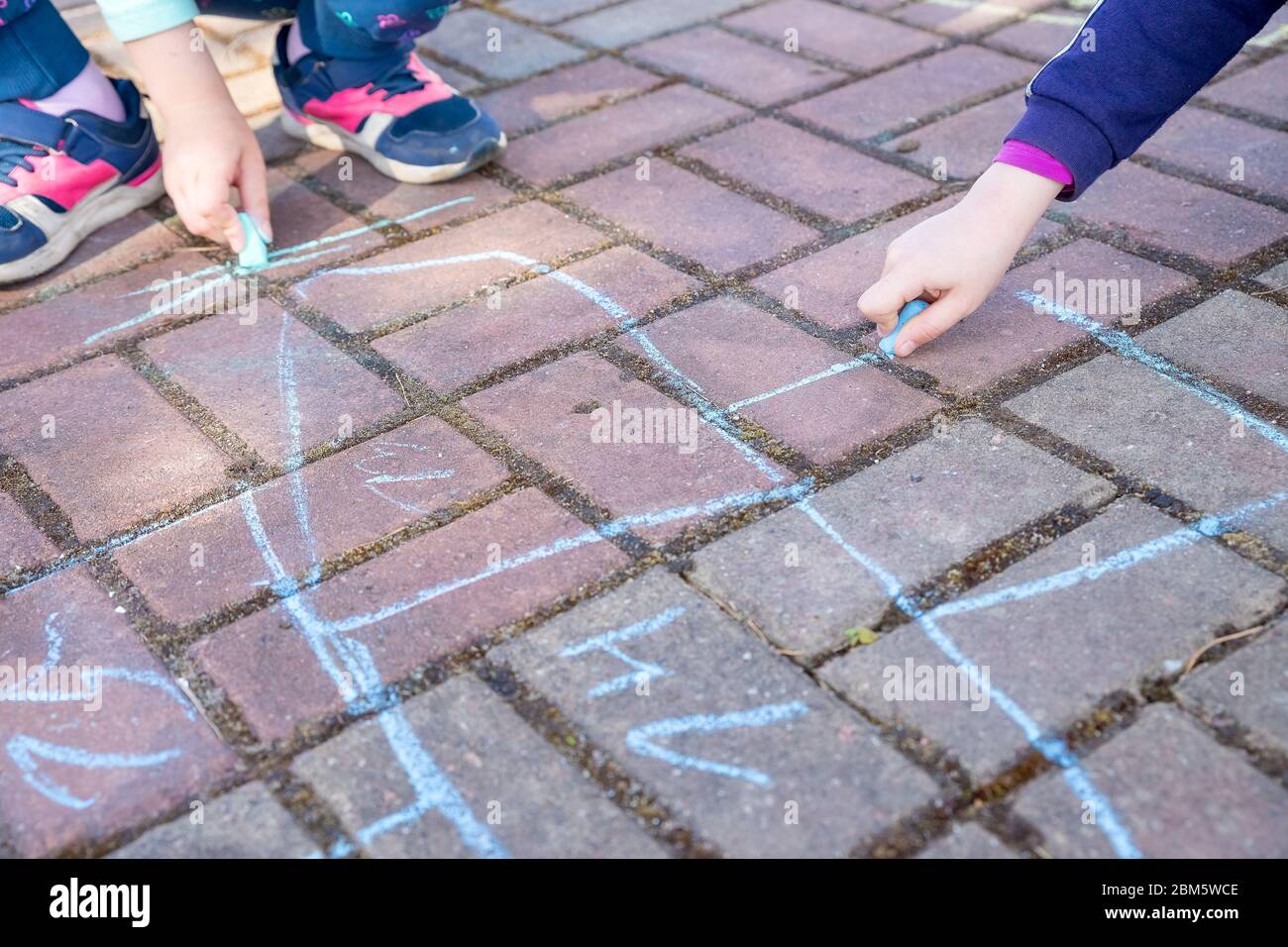 girl sits on concrete asphalt road., on stone pathway. kids painting ...