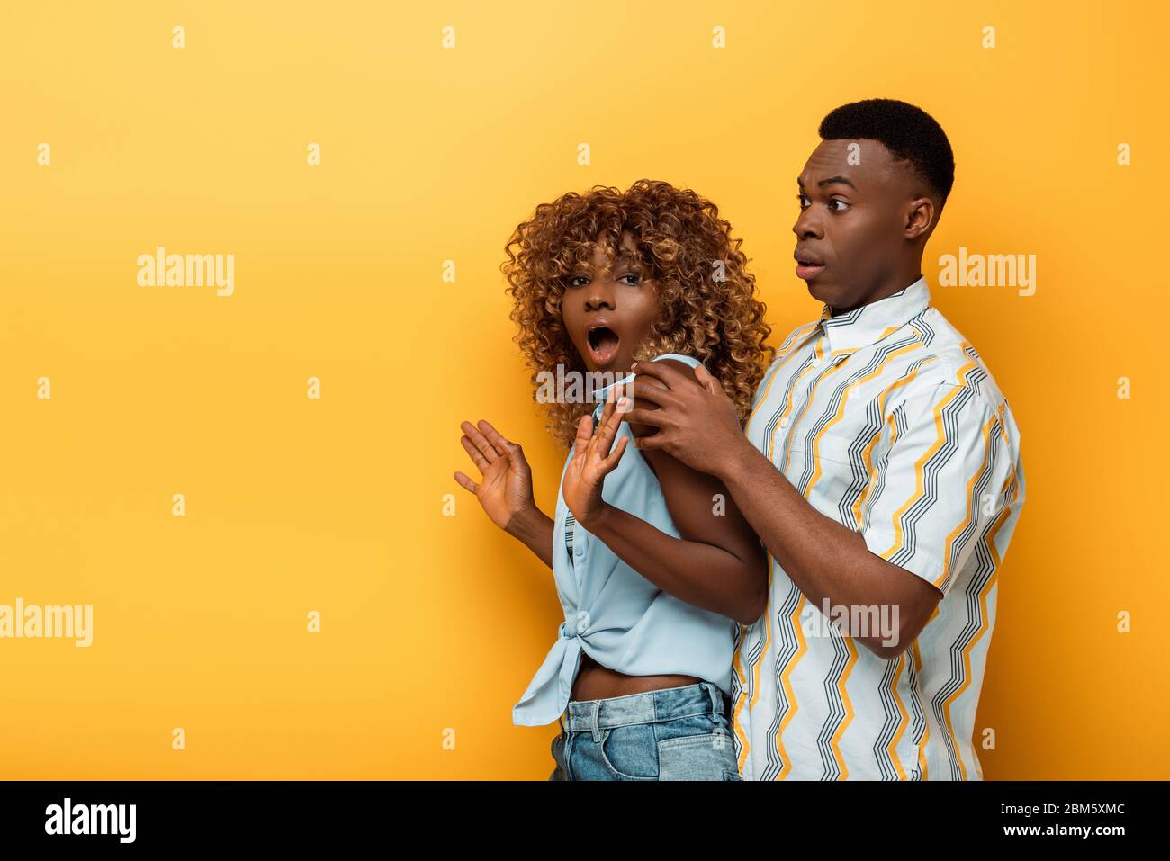 side view of scared african american couple on yellow colorful ...