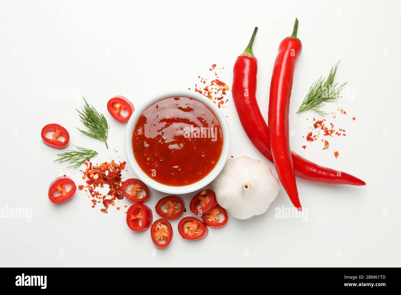 Bowl with chilli sauce, pepper and garlic on white background Stock ...