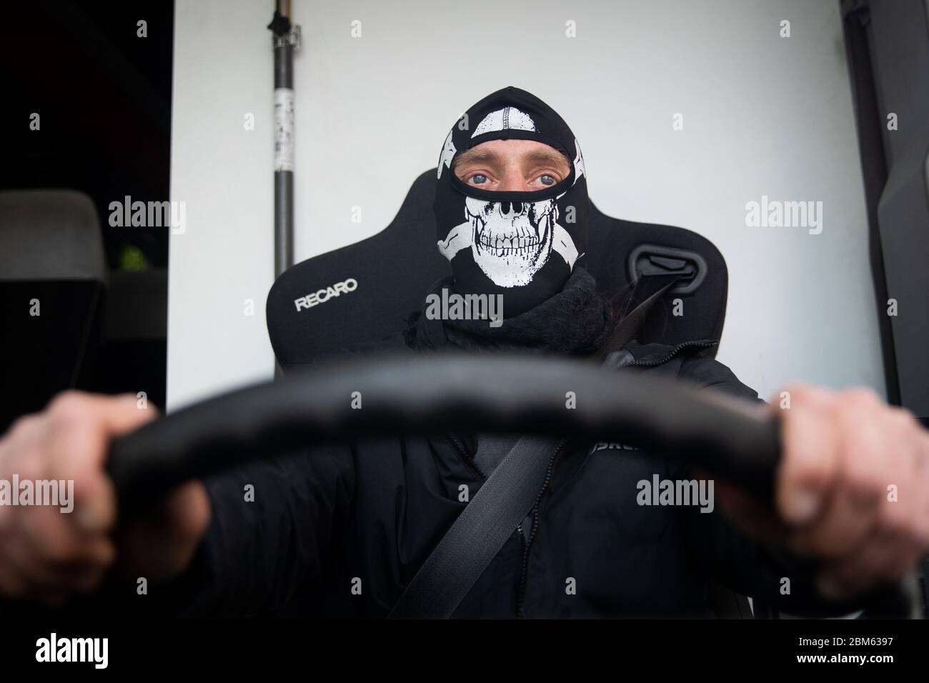 07 May 2020, Hamburg: A bus driver with a skull mask sits at the wheel ...