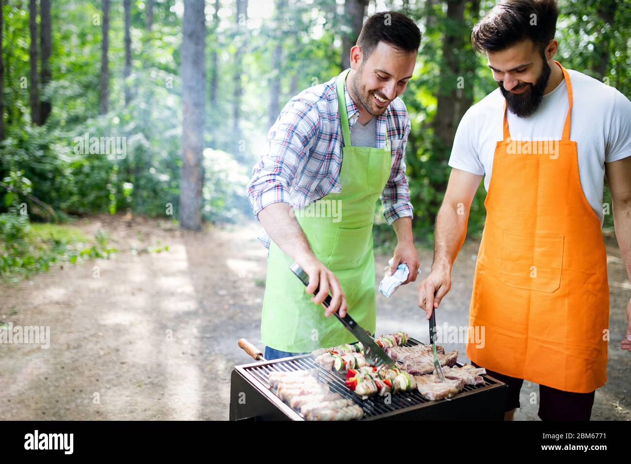 Group of friends making barbecue in the nature. Eating and sharing ...