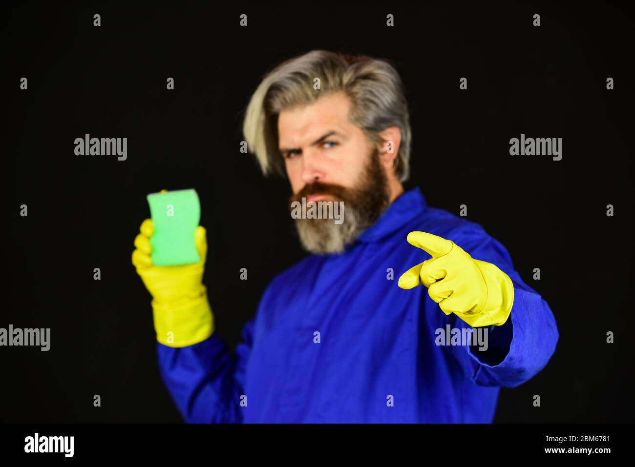 bearded man in yellow rubber gloves wiping dust using duster. cleaning ...