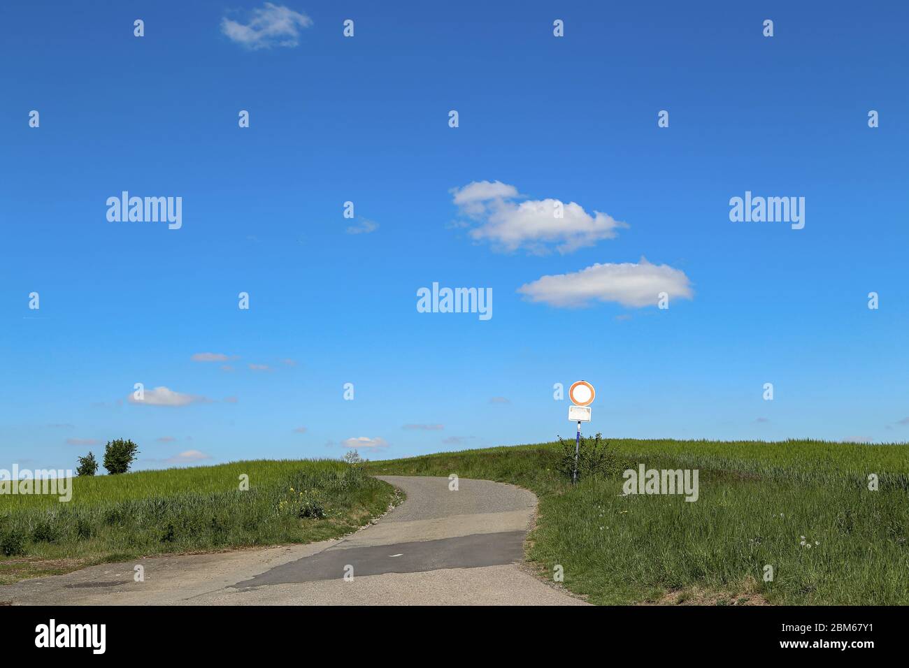 Spring landscape with a road going into the sky Stock Photo - Alamy
