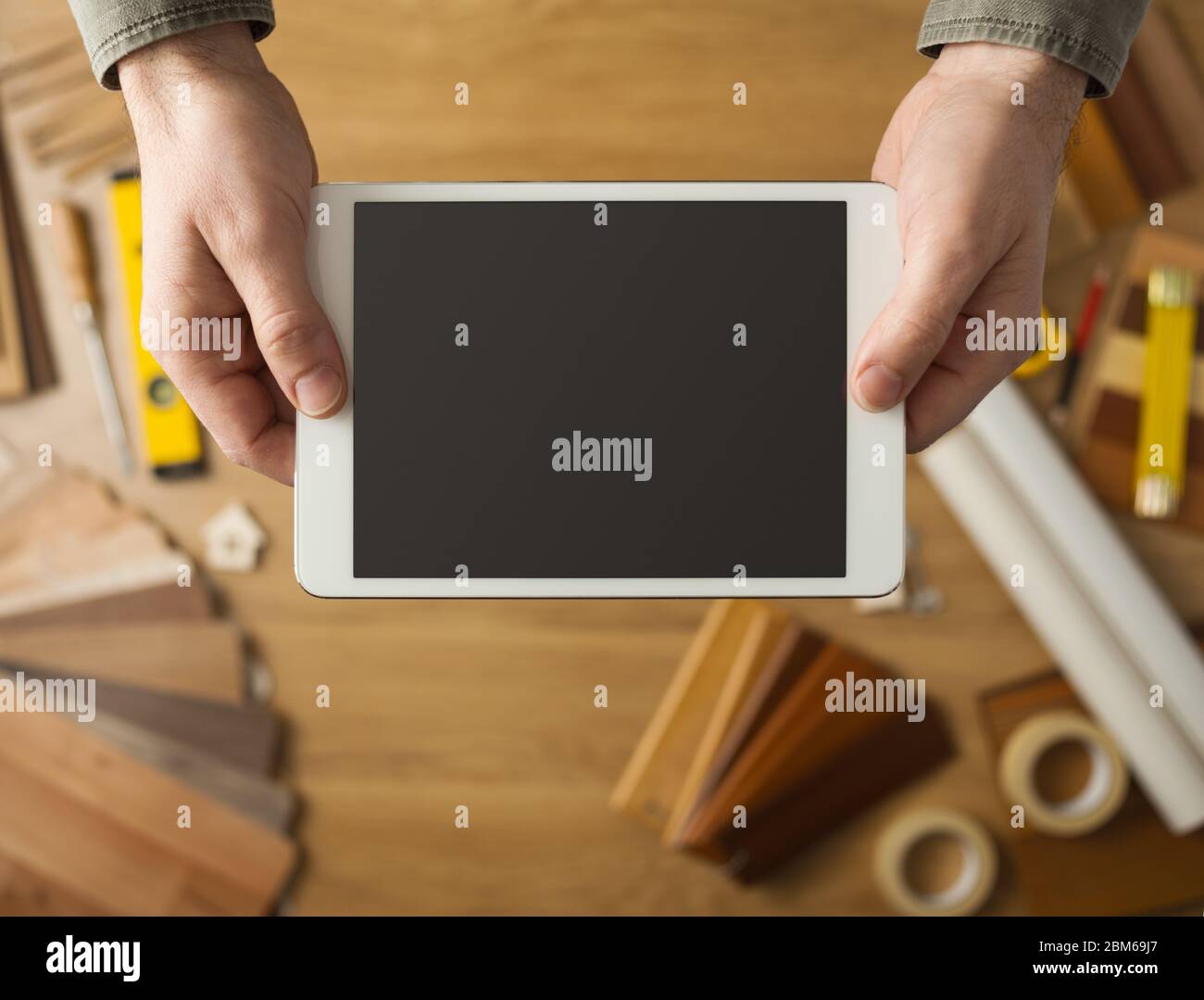 Craftsman holding a digital touch screen tablet hands close up, wood ...