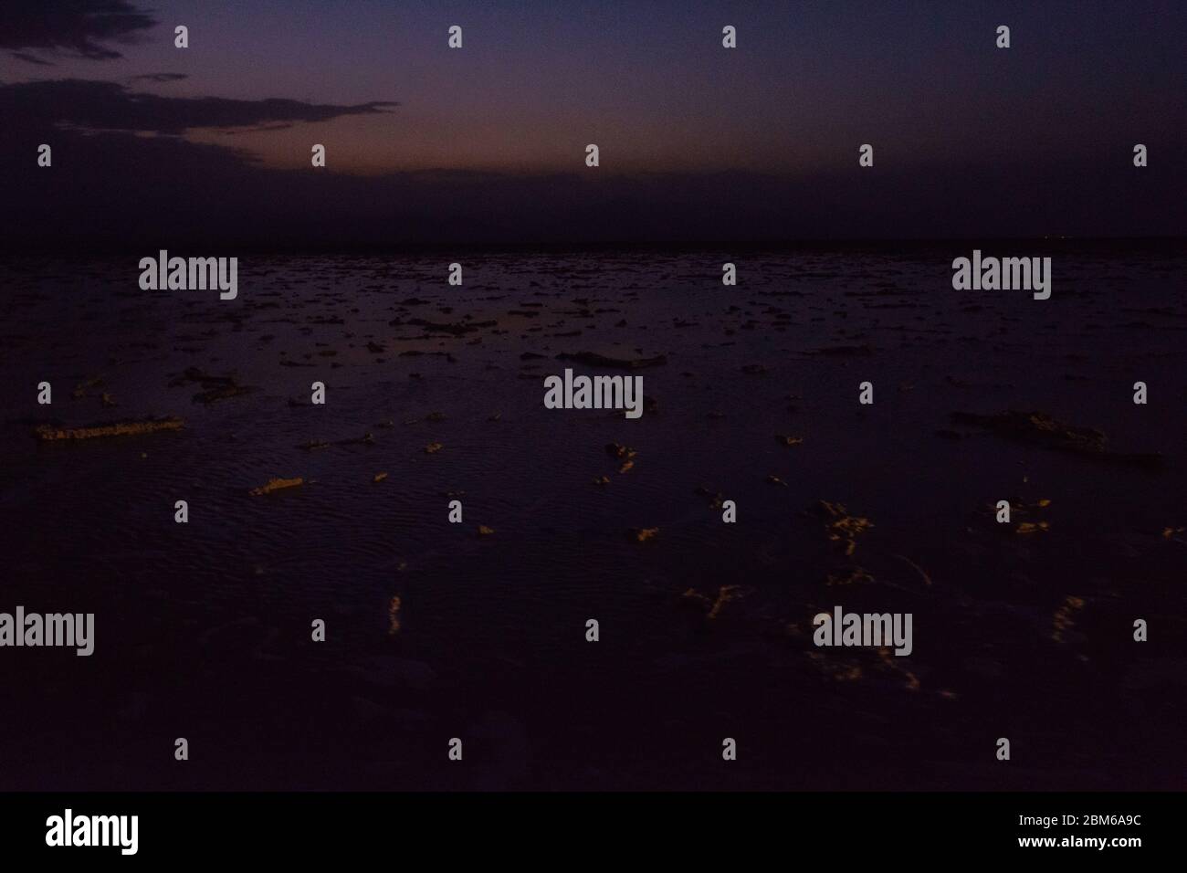 Salt flats and lake at night in Danakil desert with Erta Ale volcano in ...