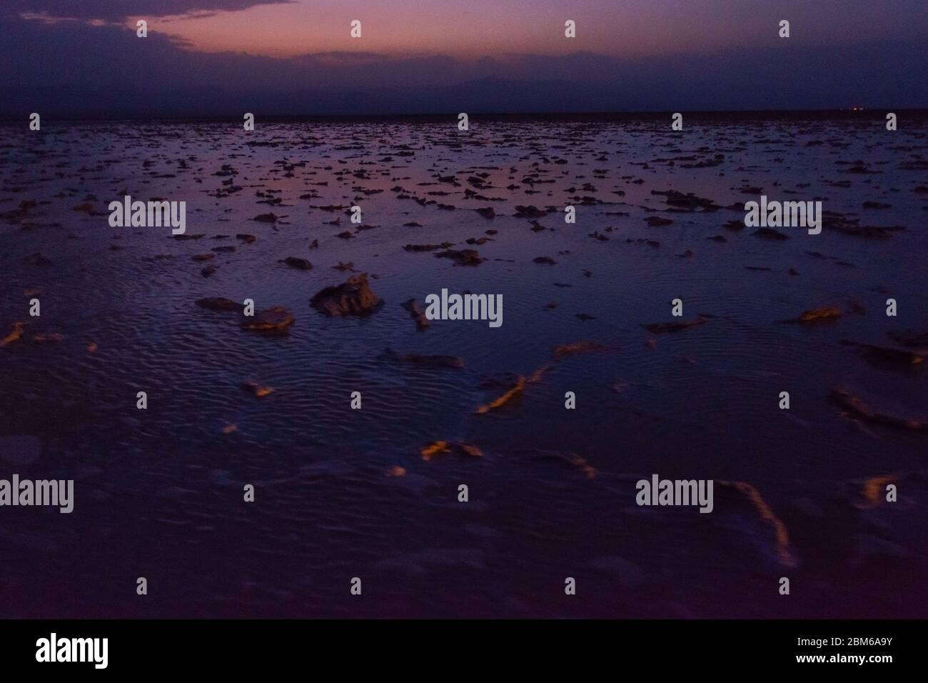 Salt flats and lake at night in Danakil desert with Erta Ale volcano in ...