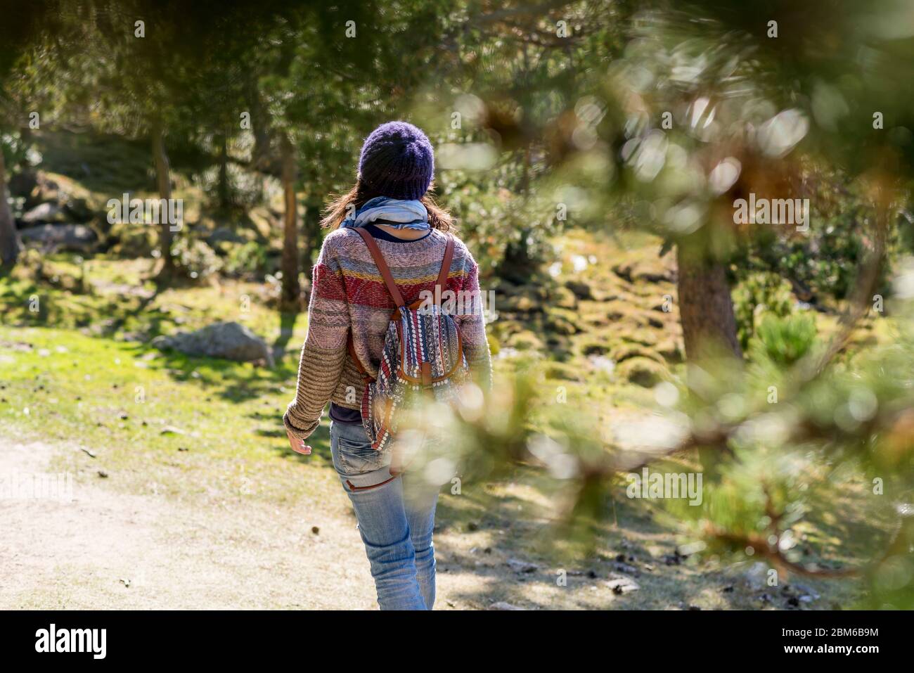 Back view of a backpacker woman wearing a wool cap hiking Stock Photo ...