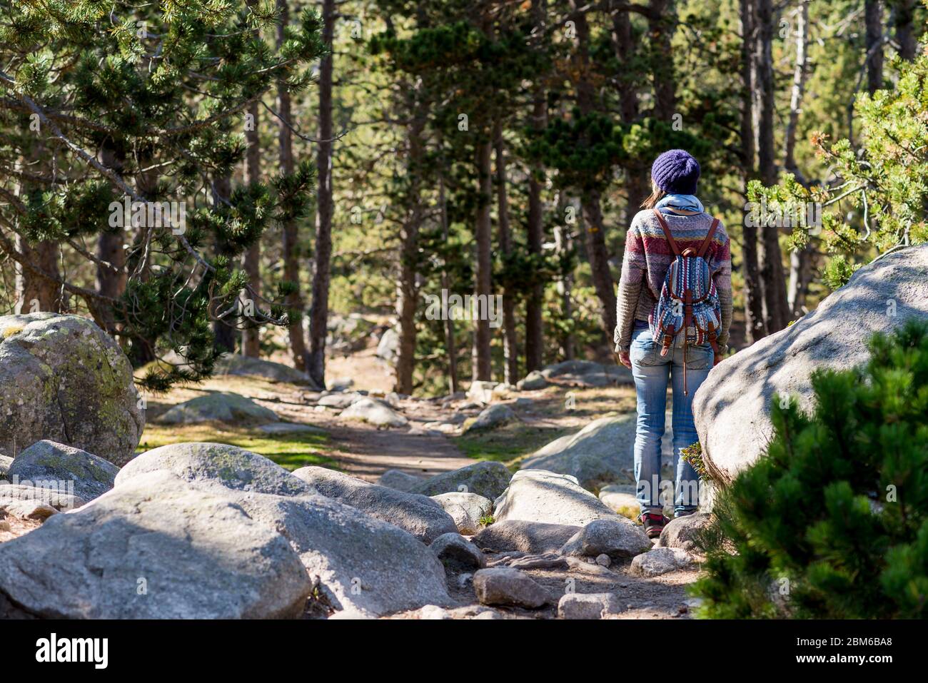 Back view of a backpacker woman wearing a wool cap hiking Stock Photo ...