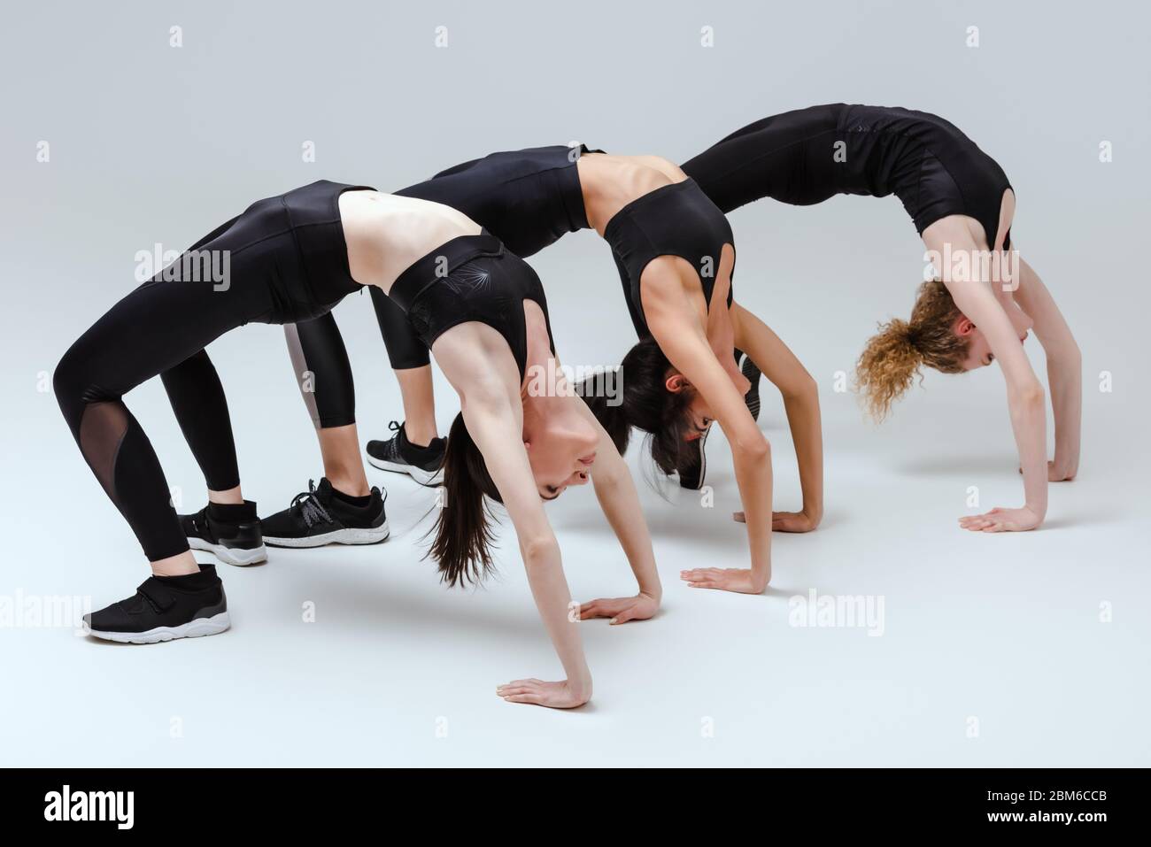 multicultural women doing bridge exercise on white Stock Photo - Alamy