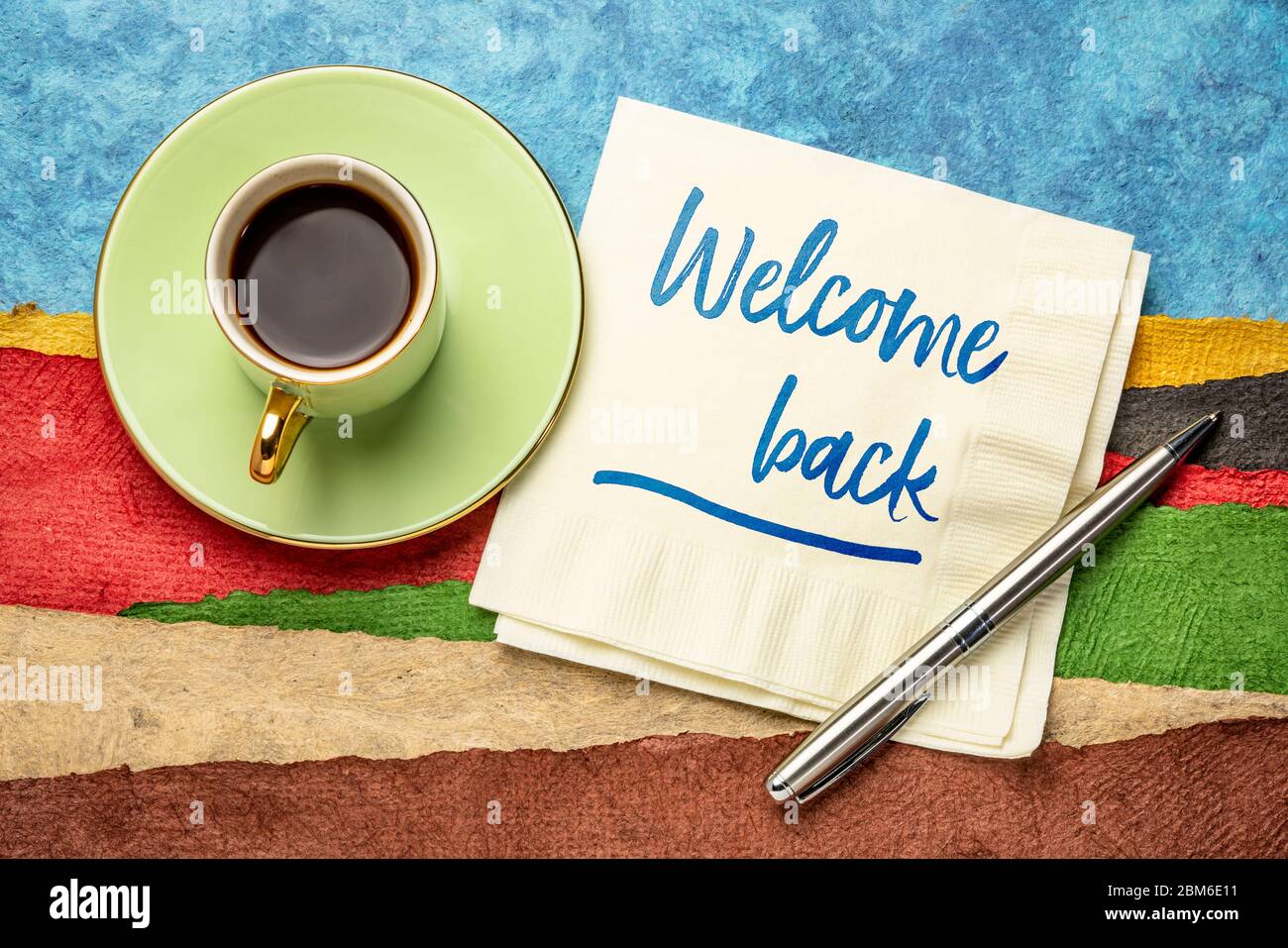Welcome back handwriting on napkin with a cup of coffee against ...