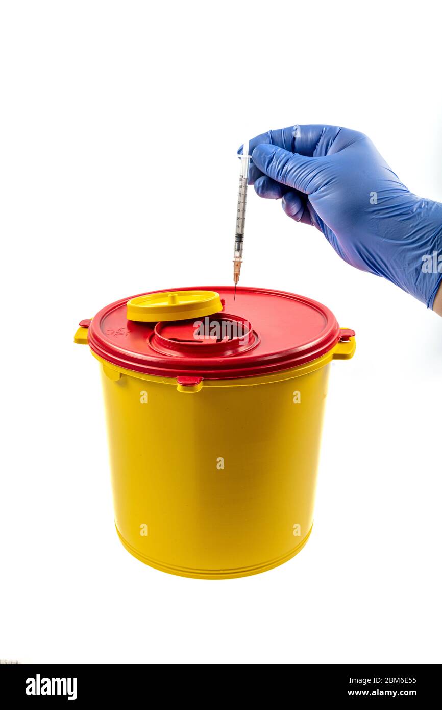 Closeup of hand depositing a used lancet on waste needle container ...