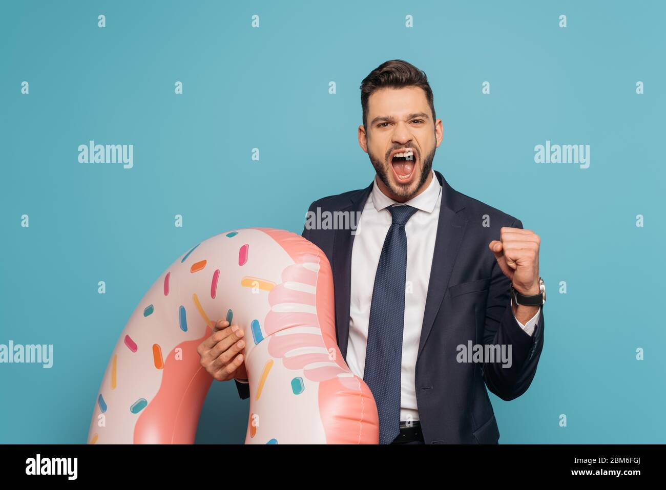 excited businessman showing yes gesture and shouting while holding ...