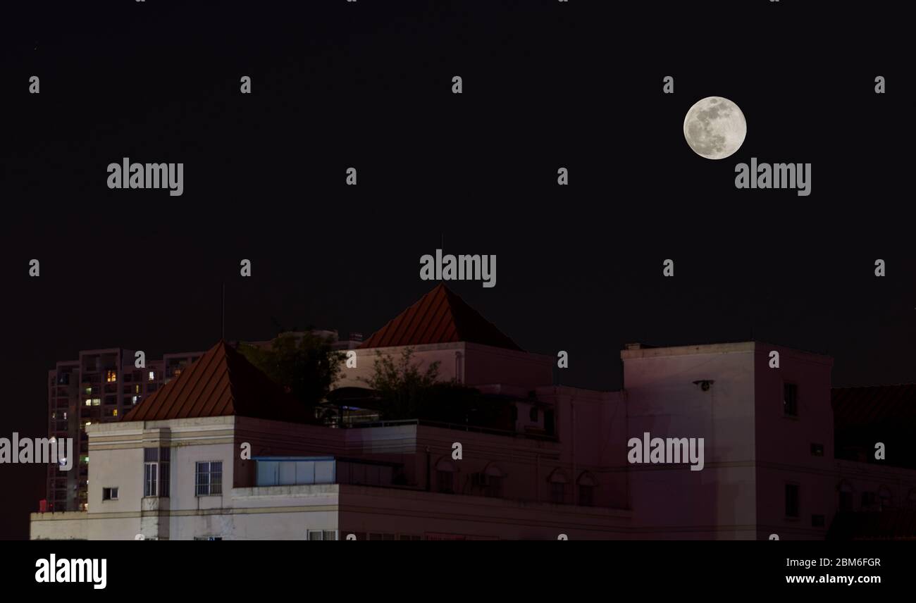 Super moon at night, big full moon and city buildings Stock Photo - Alamy
