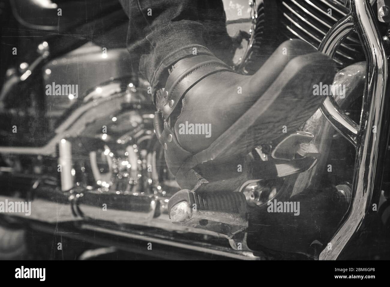 Biker riding a motorcycle. Bottom view of the legs in leather cowboy ...