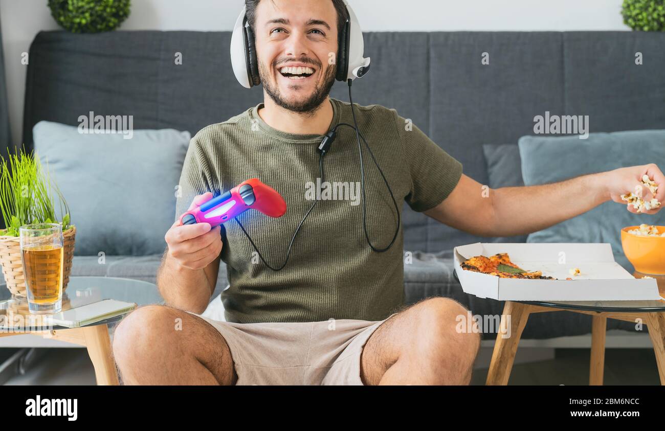 Happy man playing online video games - Young gamer having fun on new ...