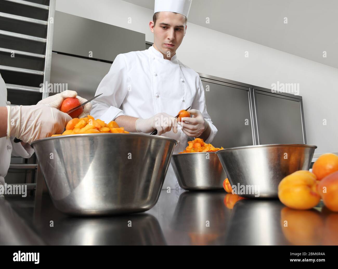 pastry chef at work in professional kitchen, makes apricot jam for the ...
