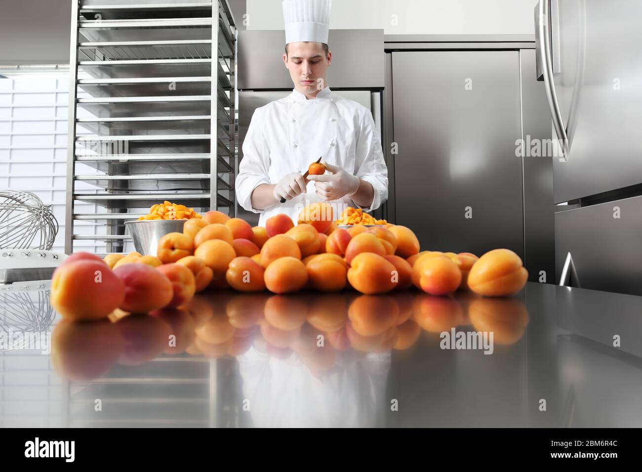 pastry chef at work in professional kitchen, makes apricot jam for the ...