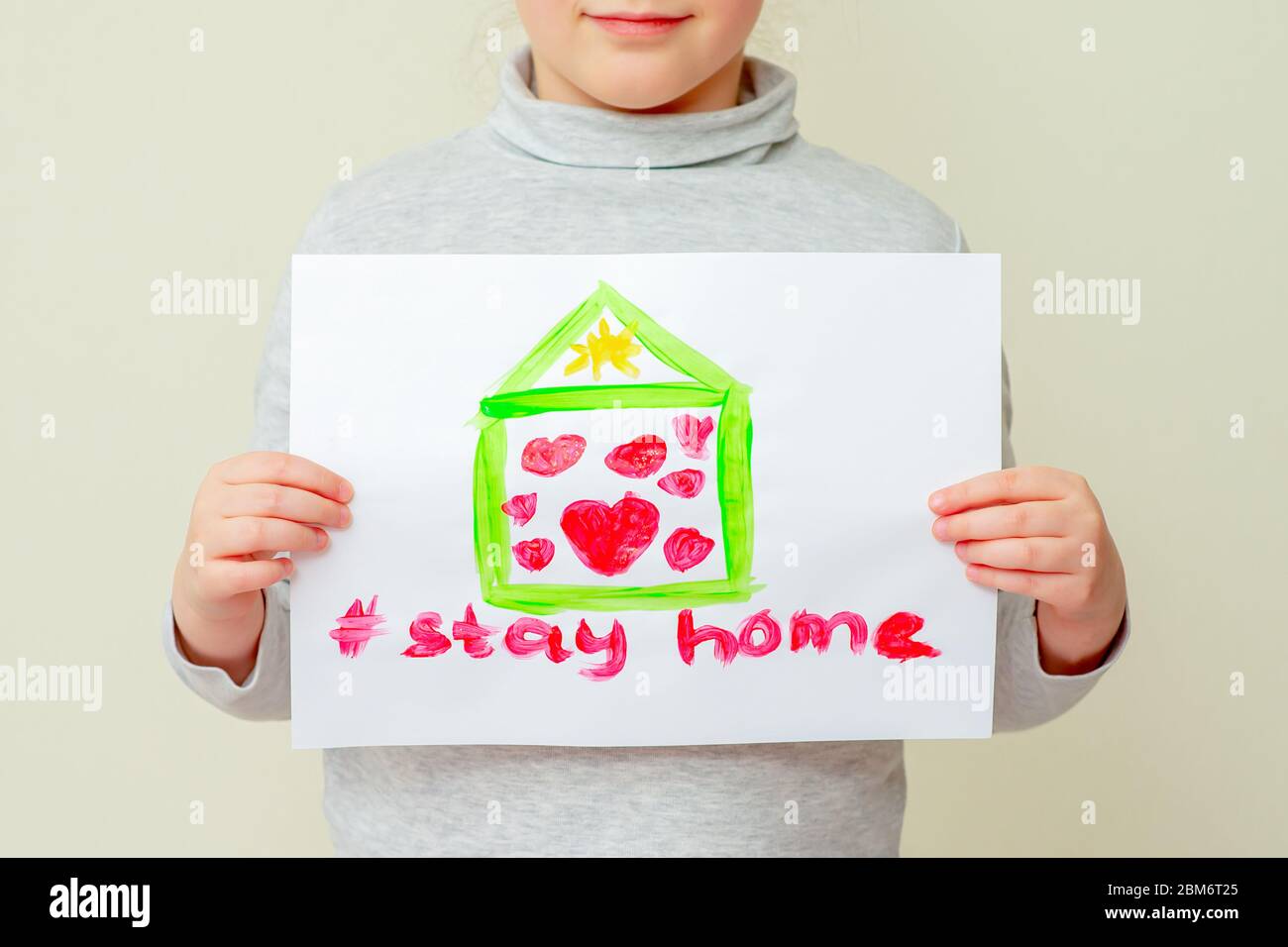 Child's hands holding a picture of house with hearts and words Stay ...