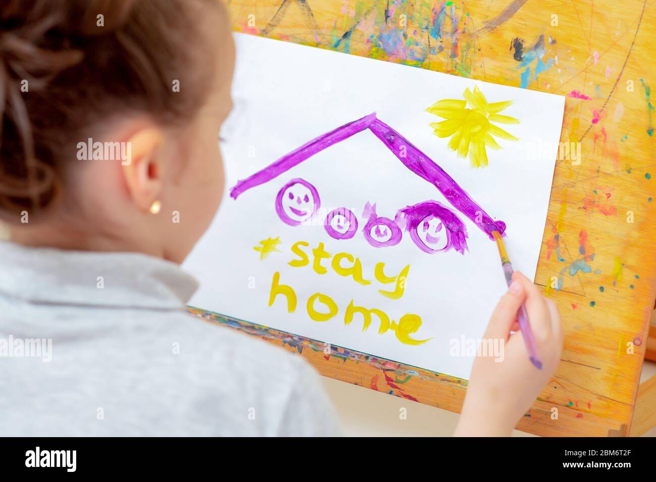 Child is drawing picture of family sketch under roof and words Stay ...
