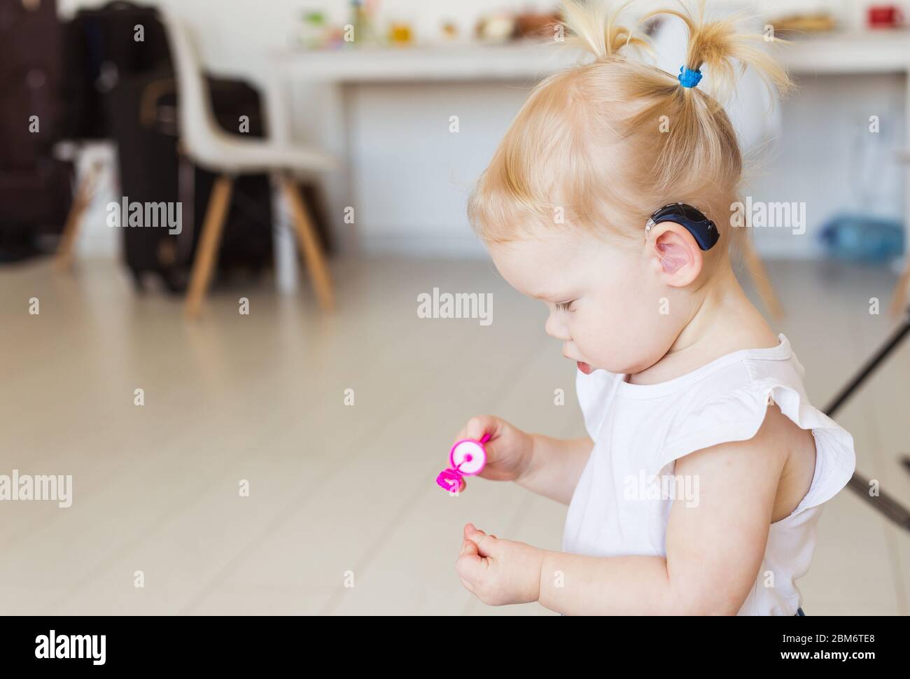 Baby girl wearing a hearing aid. Disabled child, disability and ...