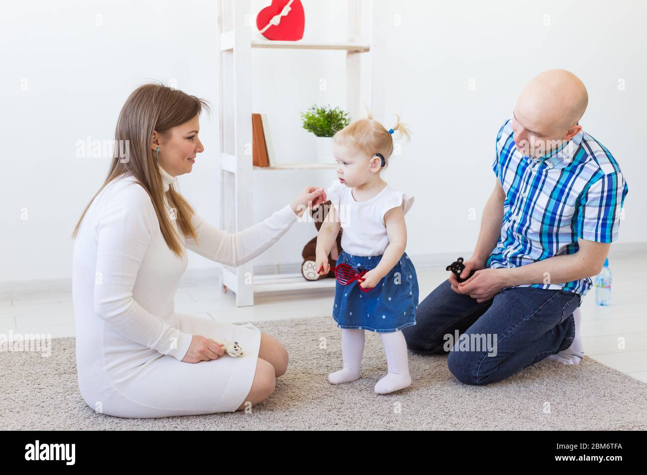 Baby girl wearing a hearing aid. Disabled child, disability and ...