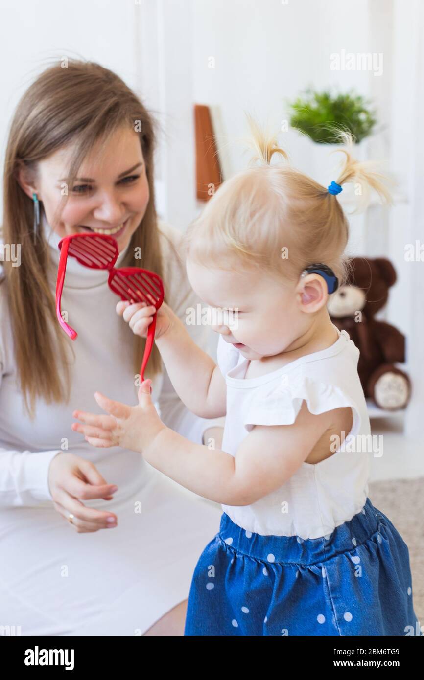 Baby girl wearing a hearing aid. Disabled child, disability and ...