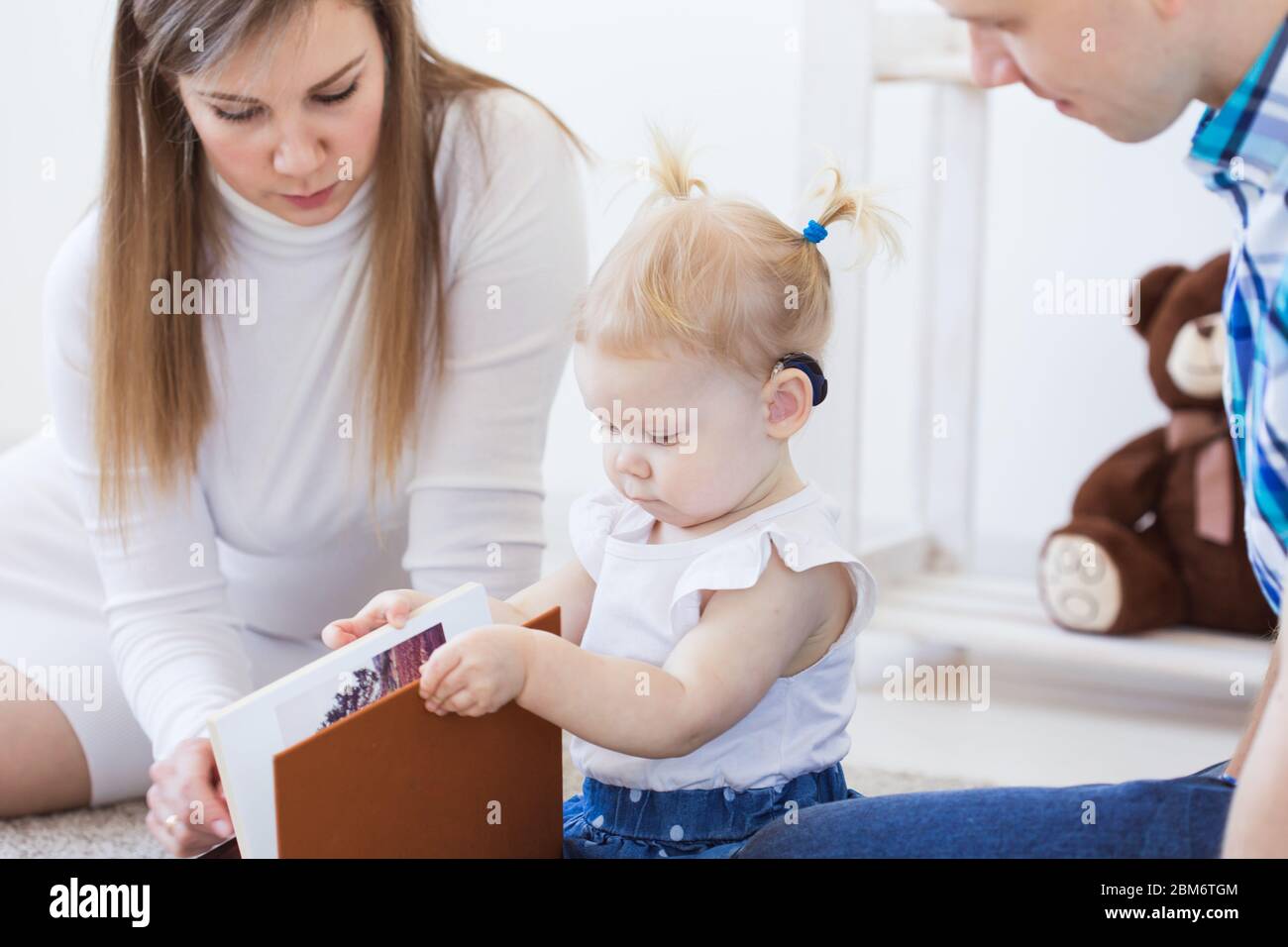 Baby girl wearing a hearing aid. Disabled child, disability and ...