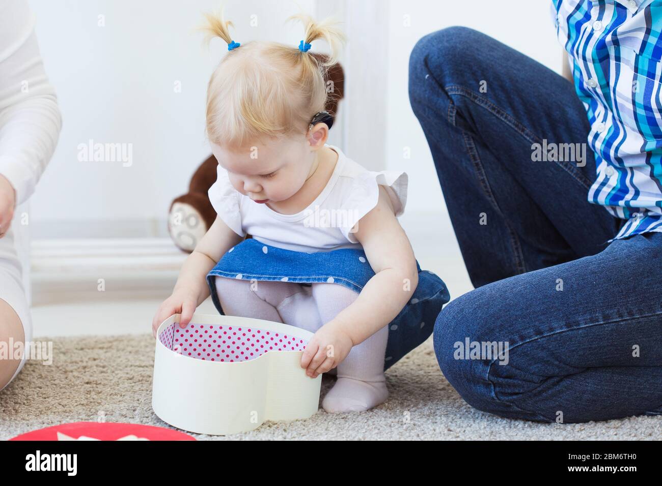 Baby girl wearing a hearing aid. Disabled child, disability and ...