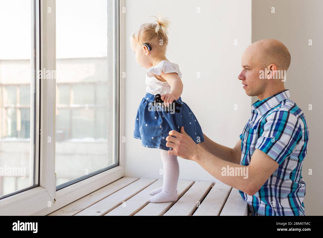 Baby girl wearing a hearing aid. Disabled child, disability and ...