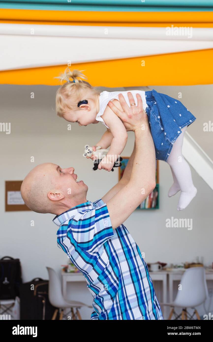 Baby girl wearing a hearing aid. Disabled child, disability and ...