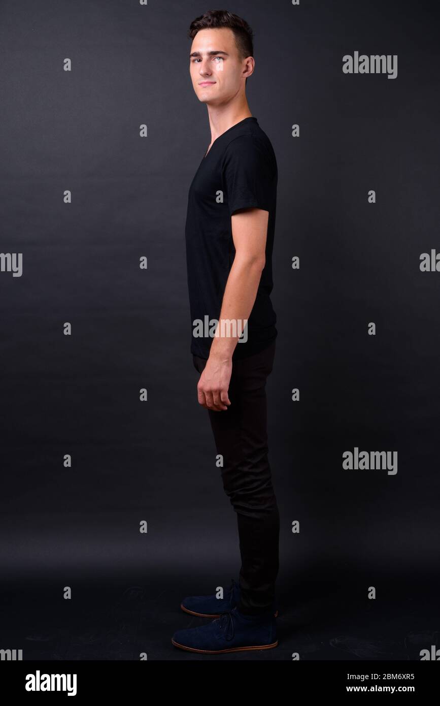 Full body shot profile view of young handsome man looking at camera ...