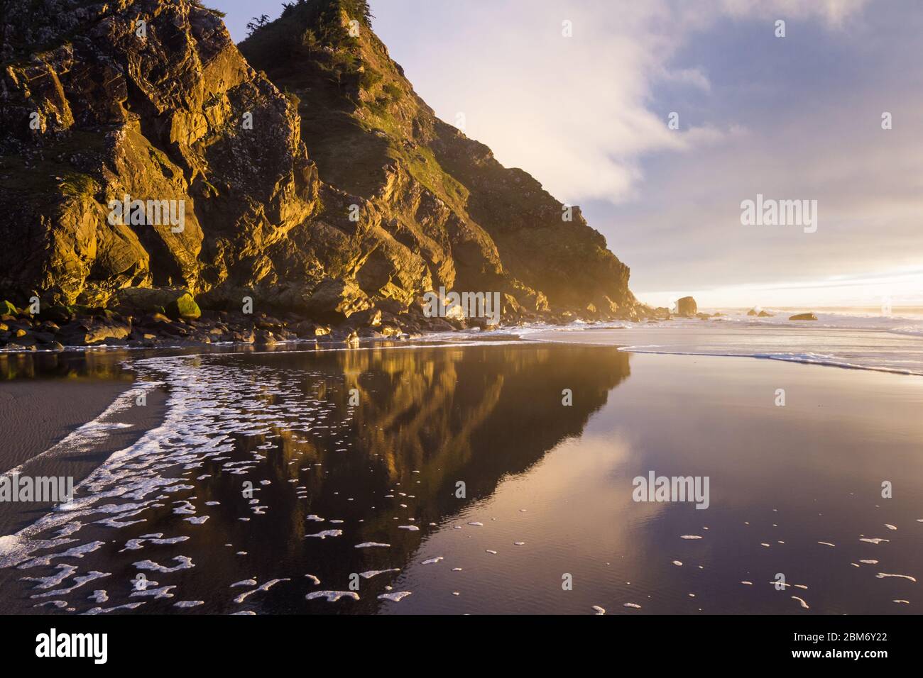 Golden light reflecting on the rocks at Cape Sebastian as the sun drops ...
