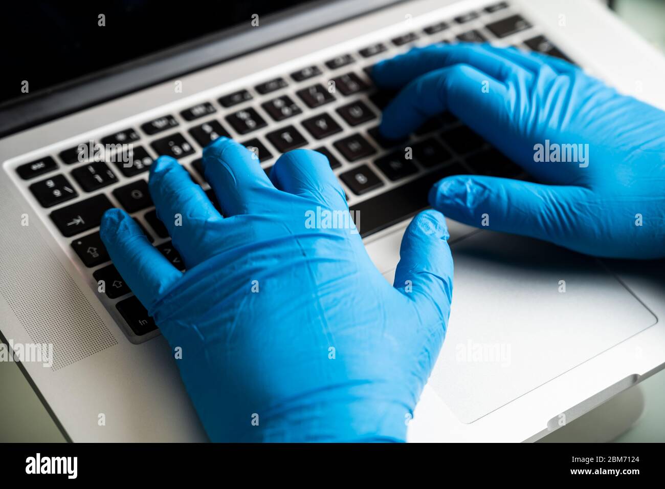 Working with protective gloves on a computer. Coronavirus prevention ...