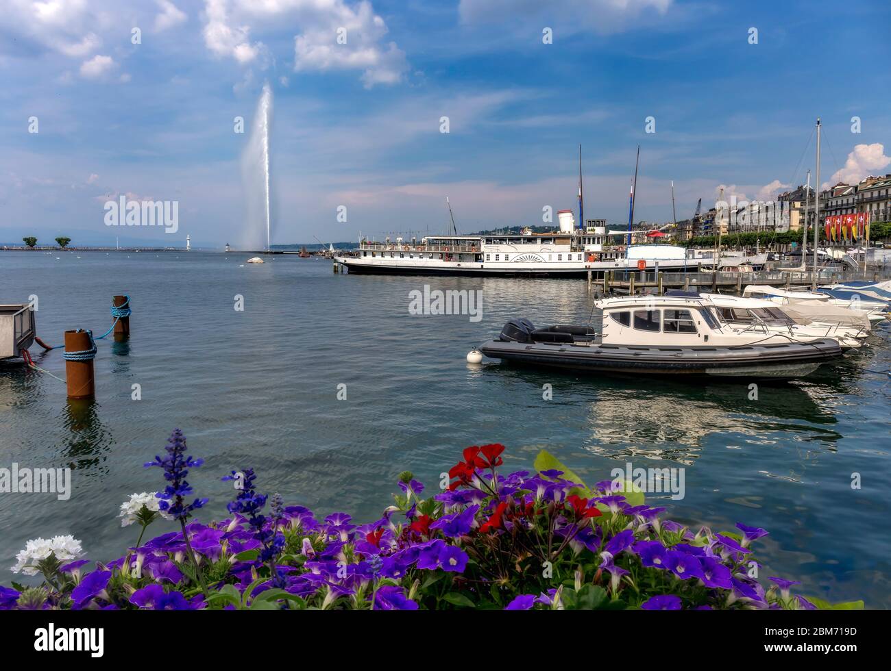 View of the fountain Jet d'Eau on lake Geneva and boats with flowers in ...