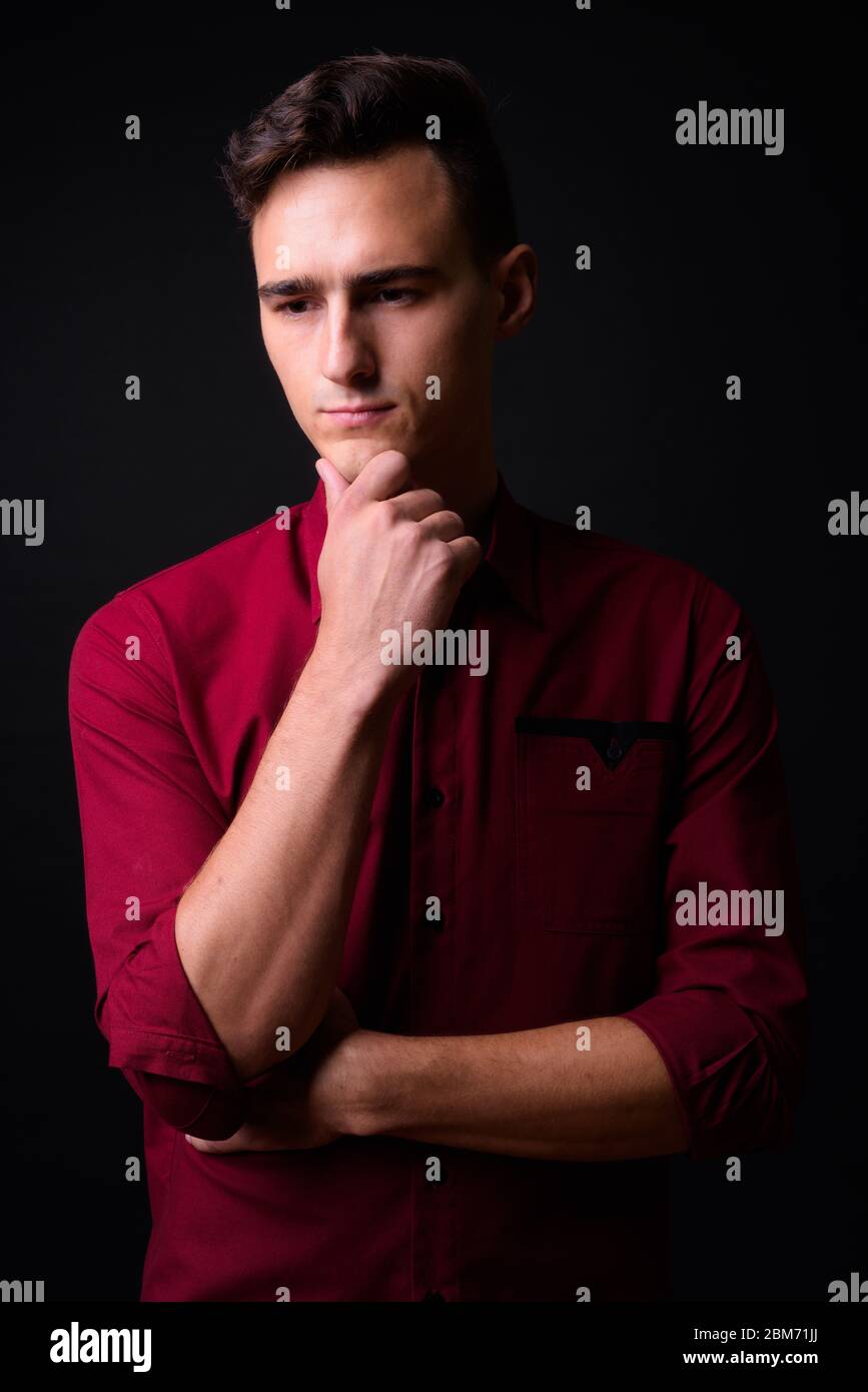 Portrait of young businessman thinking and looking down Stock Photo - Alamy