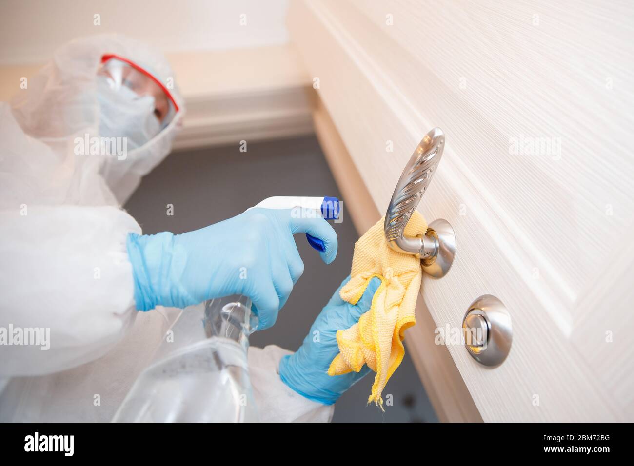 Disinfection and cleaning door handles of house from infection with ...
