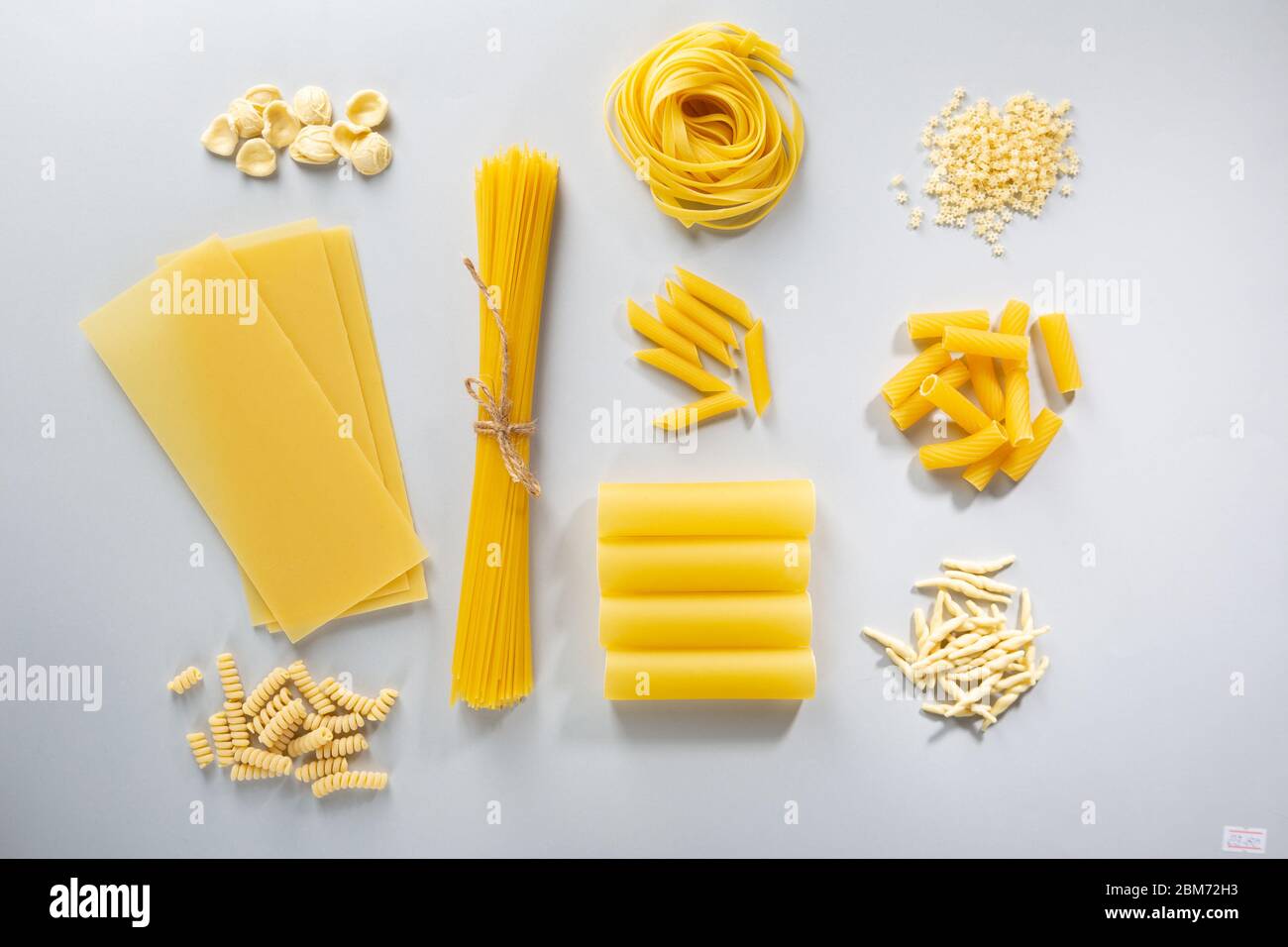 Raw pasta top view on light background Stock Photo - Alamy