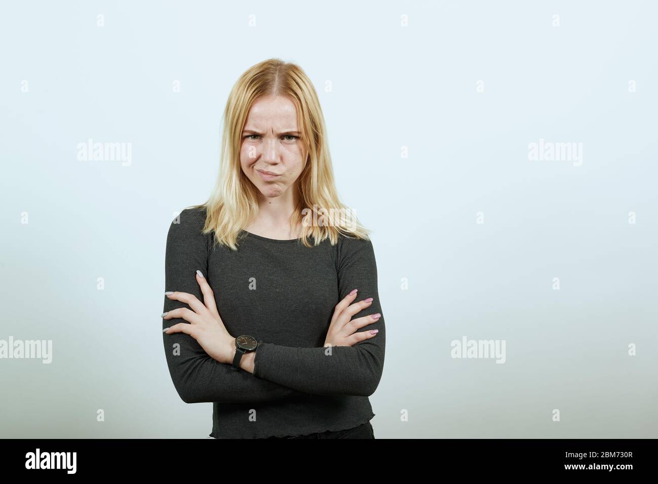 Young Blonde Woman In Black Sweater On White Background, Annoyed Girl ...